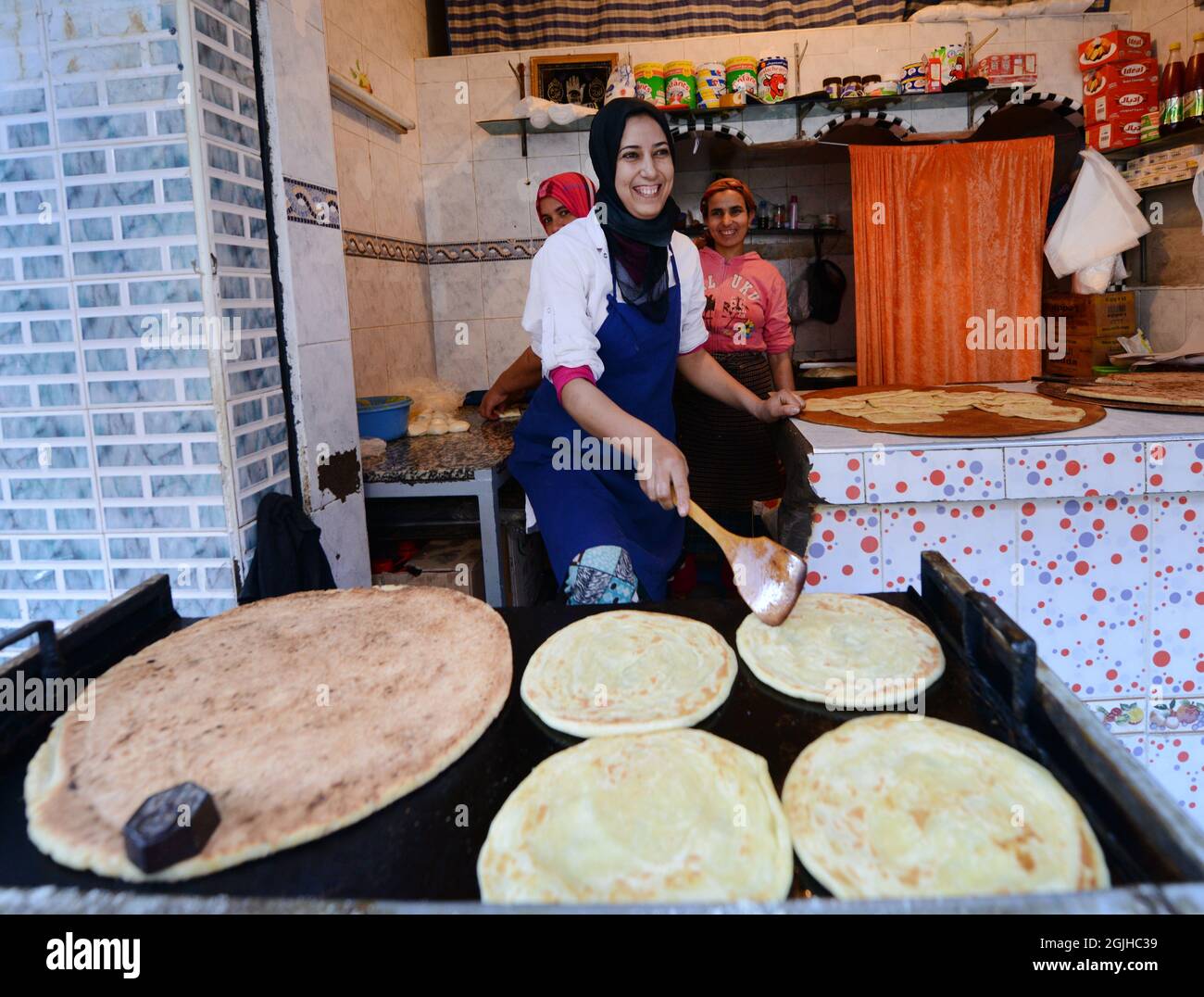 Moroccan women preparing traditional Moroccan bread in a small shop at ...