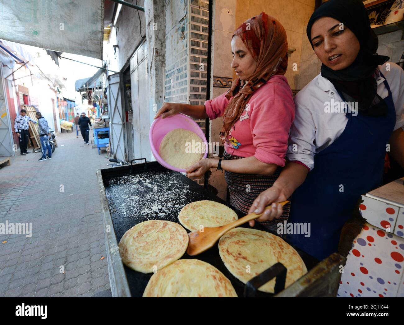 Moroccan women preparing traditional Moroccan bread in a small shop at ...
