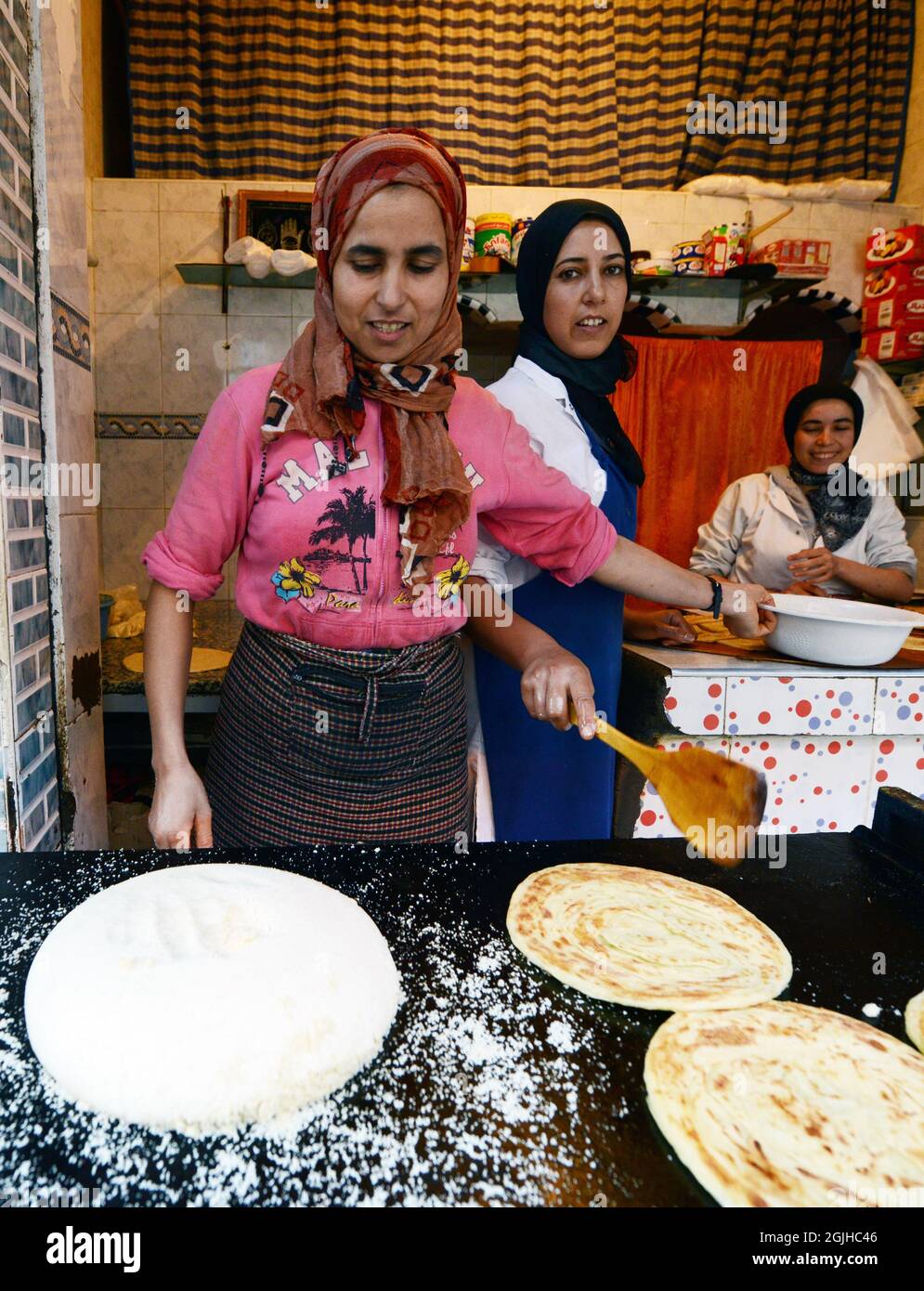 Moroccan women preparing traditional Moroccan bread in a small shop at ...