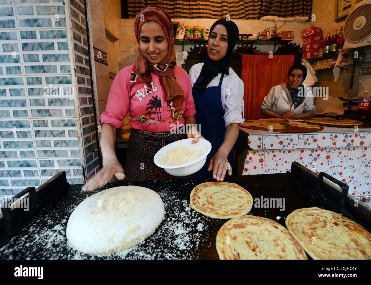 Moroccan women preparing traditional Moroccan bread in a small shop at ...