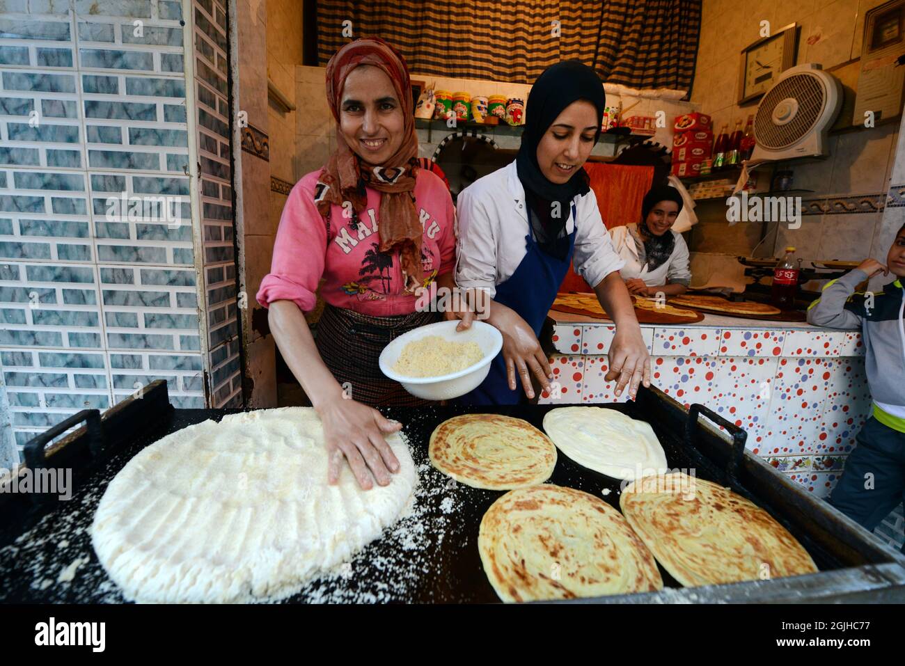 Moroccan women preparing traditional Moroccan bread in a small shop at ...