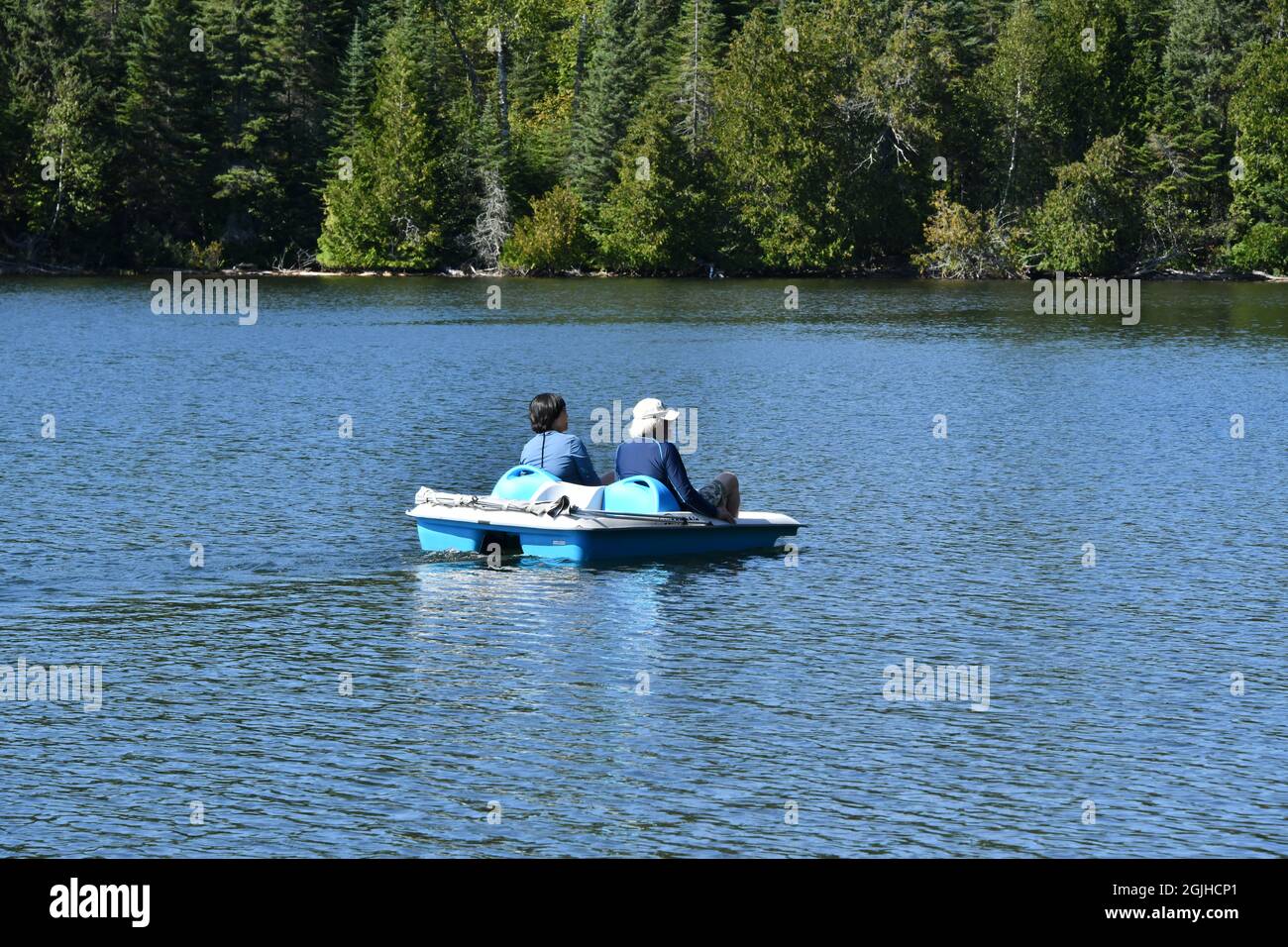 Two people enjoying a paddle boat ride around Bass Lake in Ontario ...