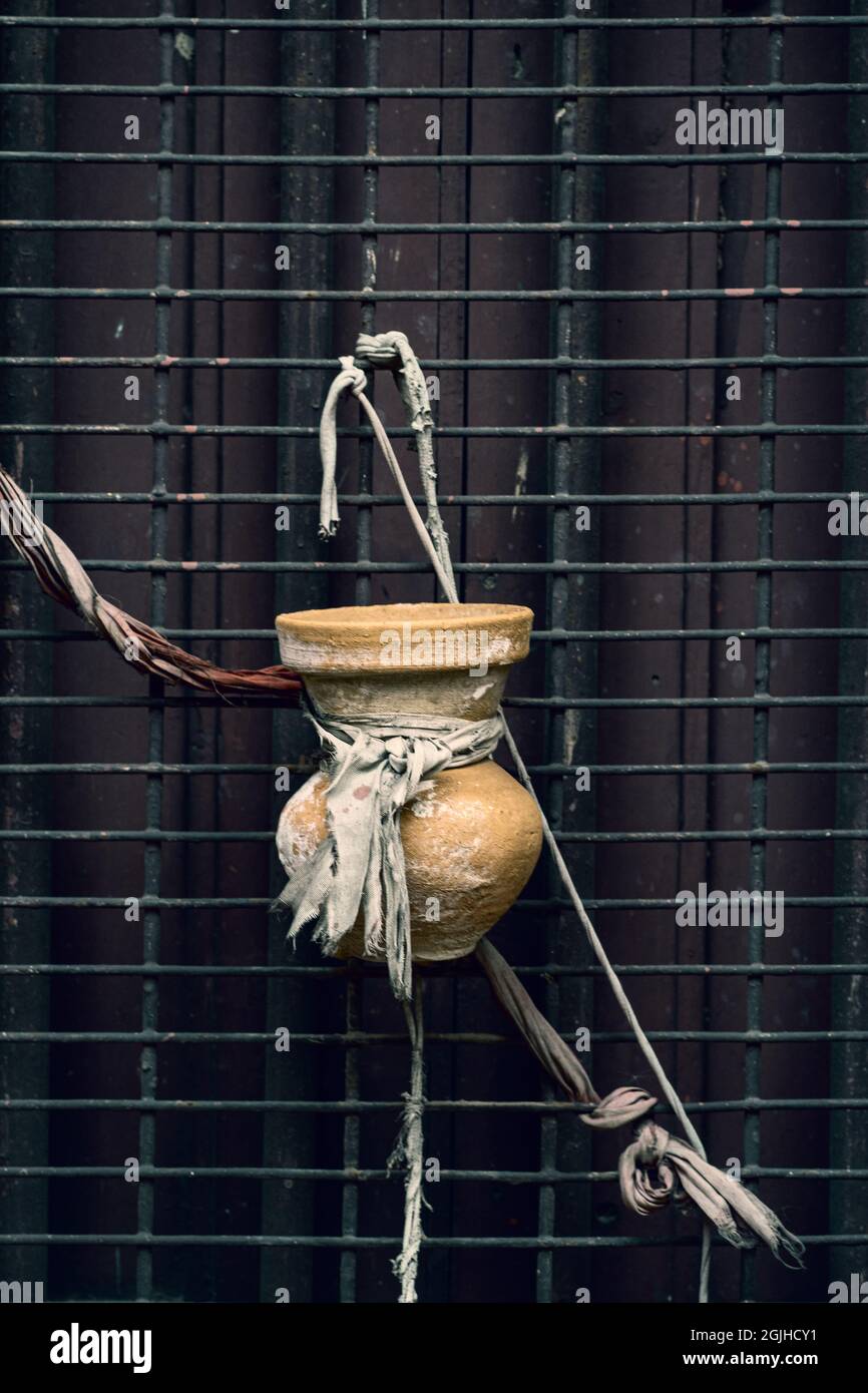 Close-up shot of a clay object connected to an iron gate with different ...