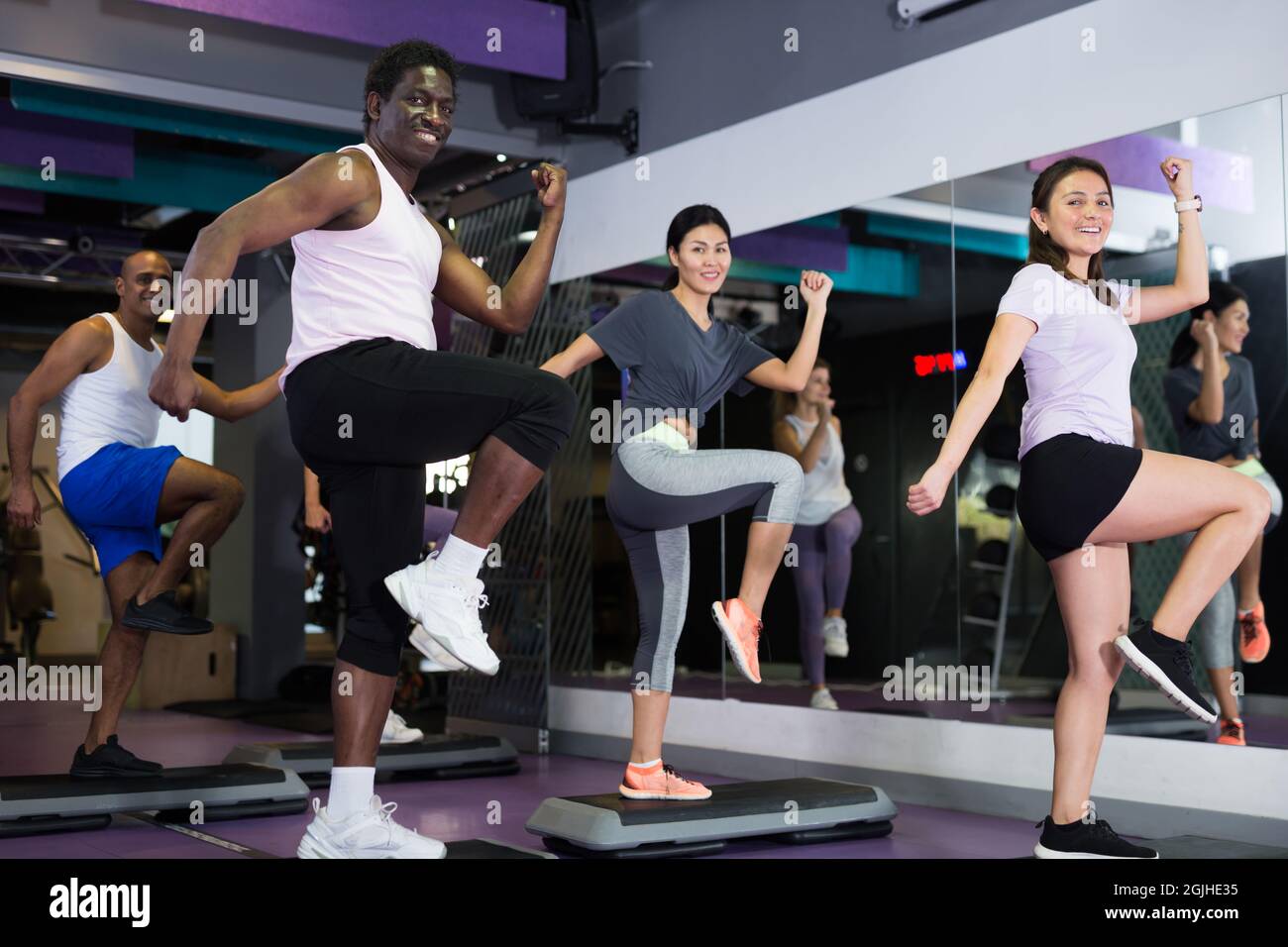 People training on step platforms in gym Stock Photo - Alamy