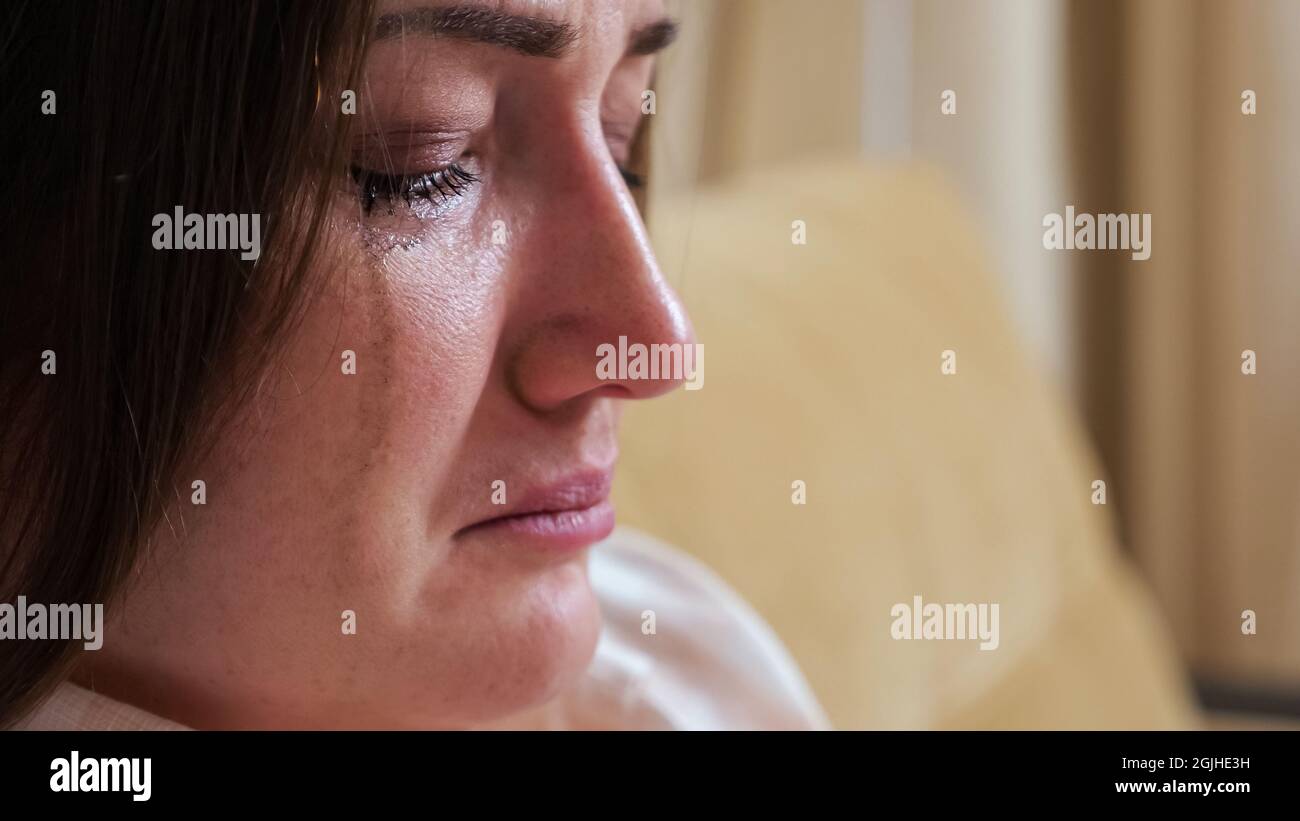 Close-up of a crying woman, blurry mascara dripping down her cheeks ...