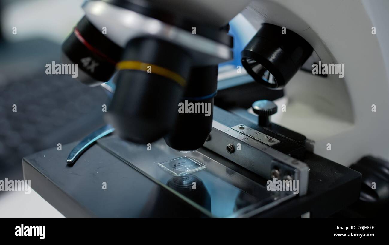 Close up of laboratory microscope with tray for fluid sample research ...