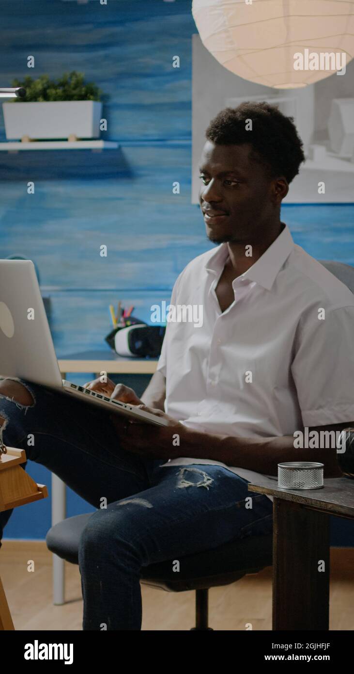 Black creative artist with laptop using technology for art design and ...