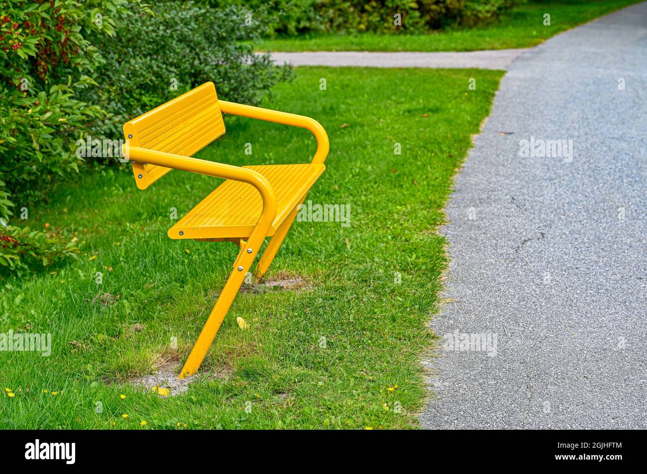 yellow painted metal bench in public park Stock Photo - Alamy
