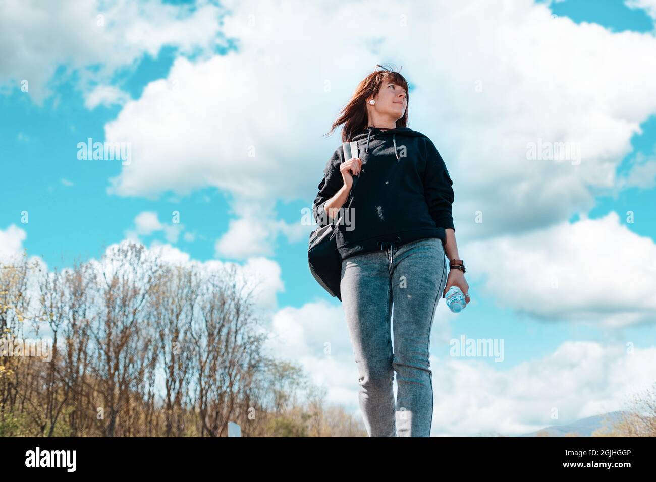 A young pretty woman walks with a backpack in her hands. Bottom view ...