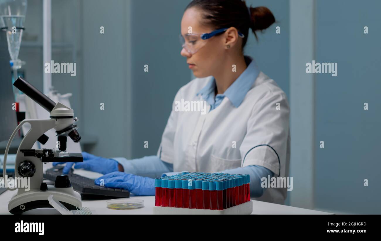 Microbiology specialist using computer in laboratory while having ...