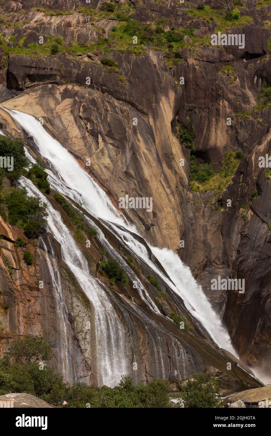 The river flows abruptly into a small lake and over a drop, creating a ...