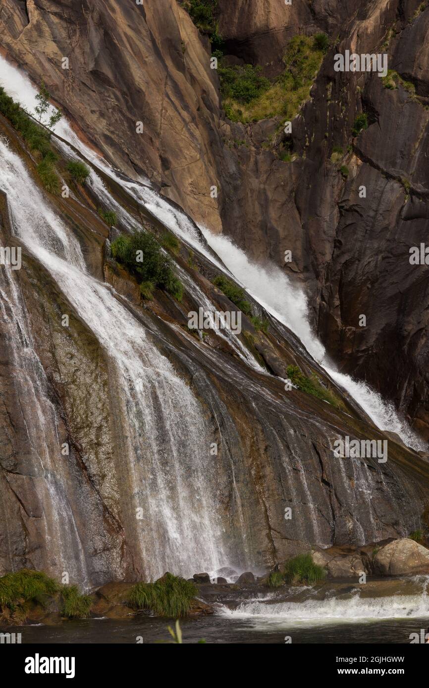 The river flows abruptly into a small lake and over a drop, creating a ...