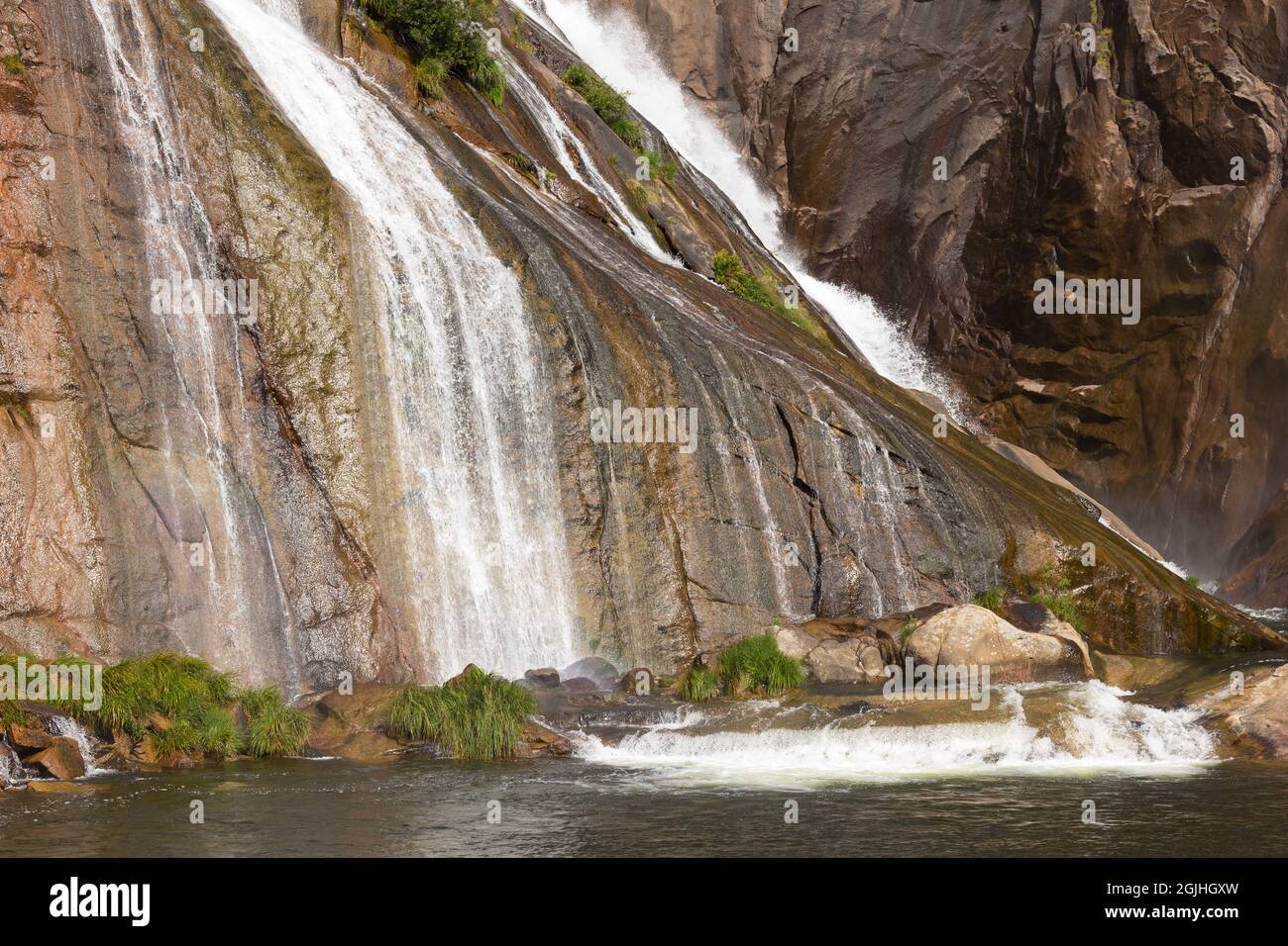 The river flows abruptly into a small lake and over a drop, creating a ...