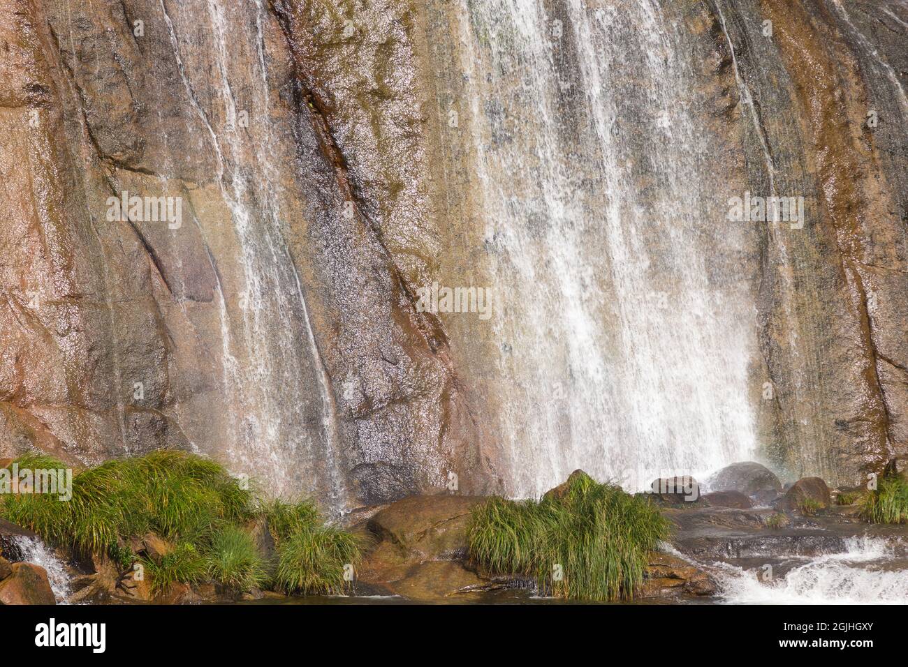 The river flows abruptly into a small lake and over a drop, creating a ...