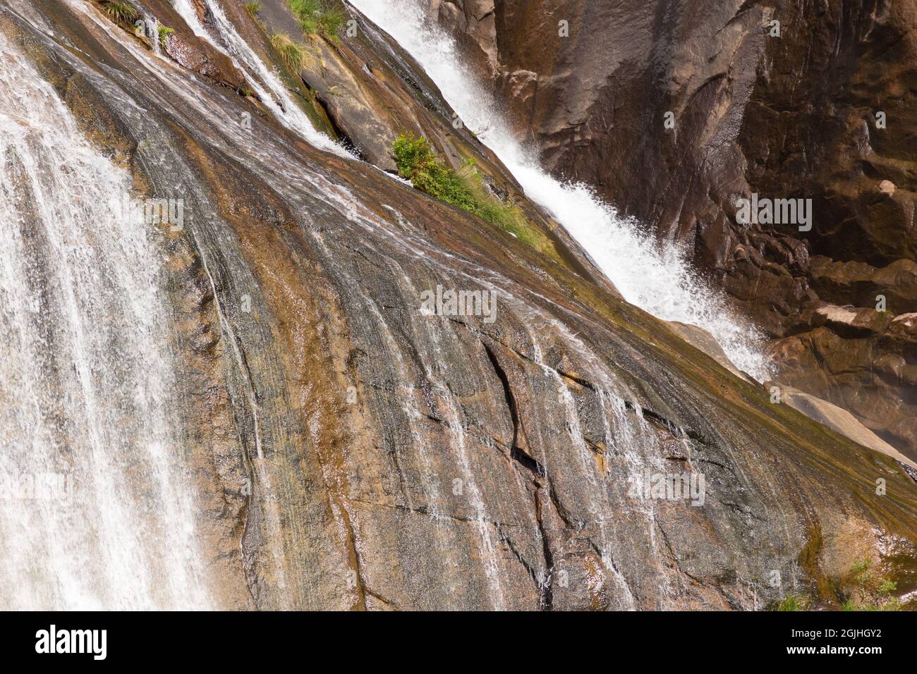 The river flows abruptly into a small lake and over a drop, creating a ...