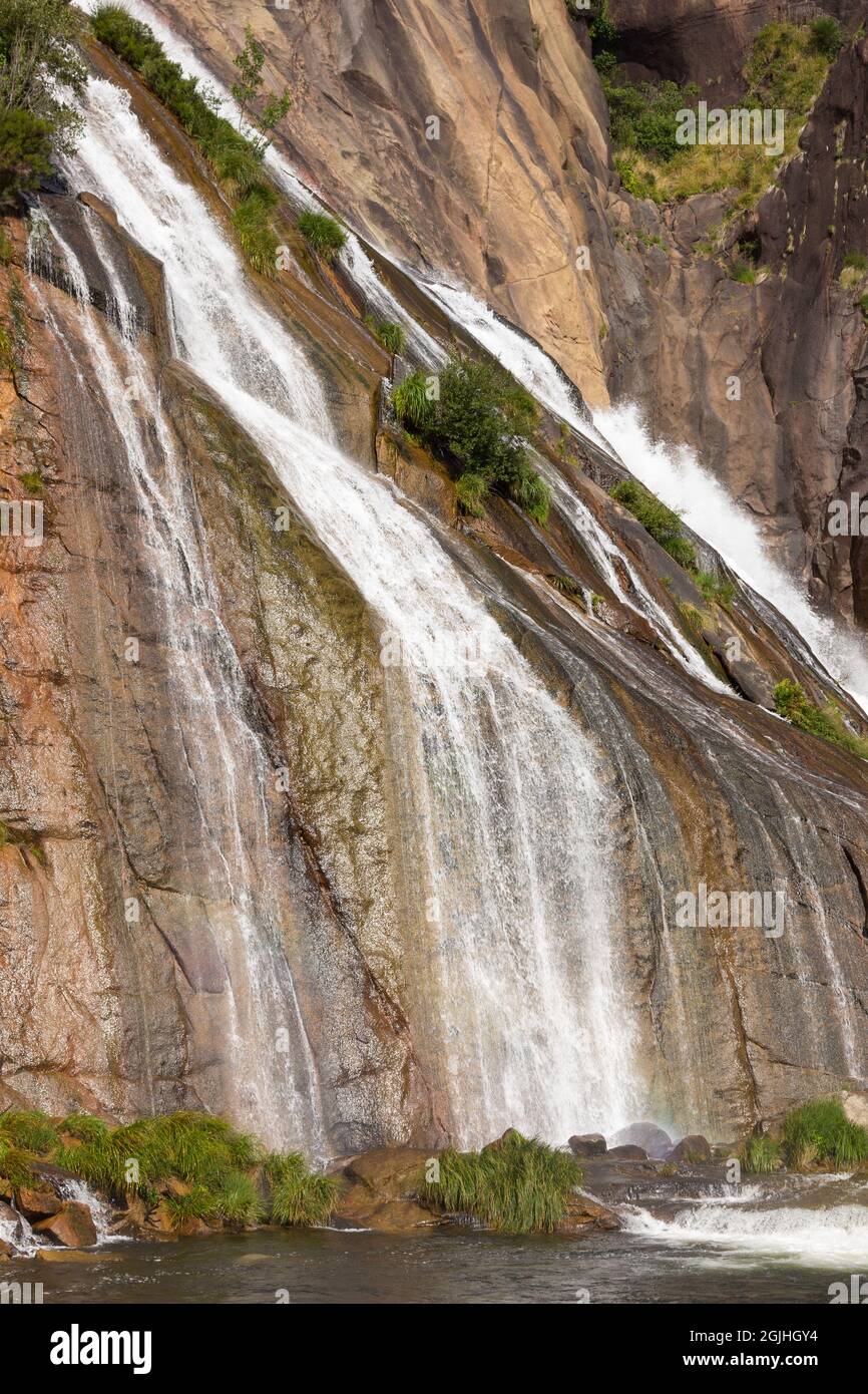 The river flows abruptly into a small lake and over a drop, creating a ...