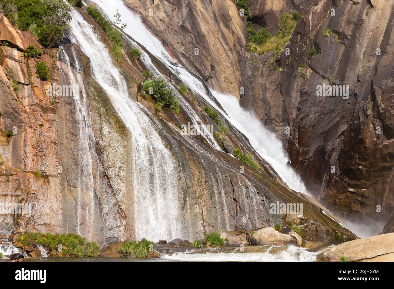 The river flows abruptly into a small lake and over a drop, creating a ...