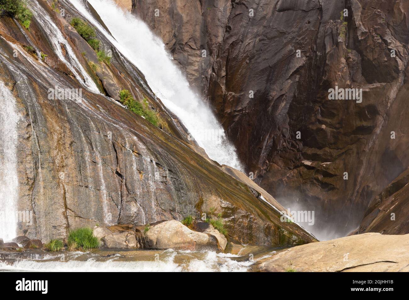 The river flows abruptly into a small lake and over a drop, creating a ...