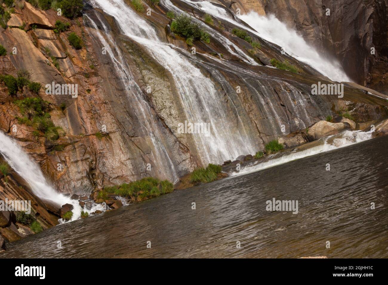 The river flows abruptly into a small lake and over a drop, creating a ...
