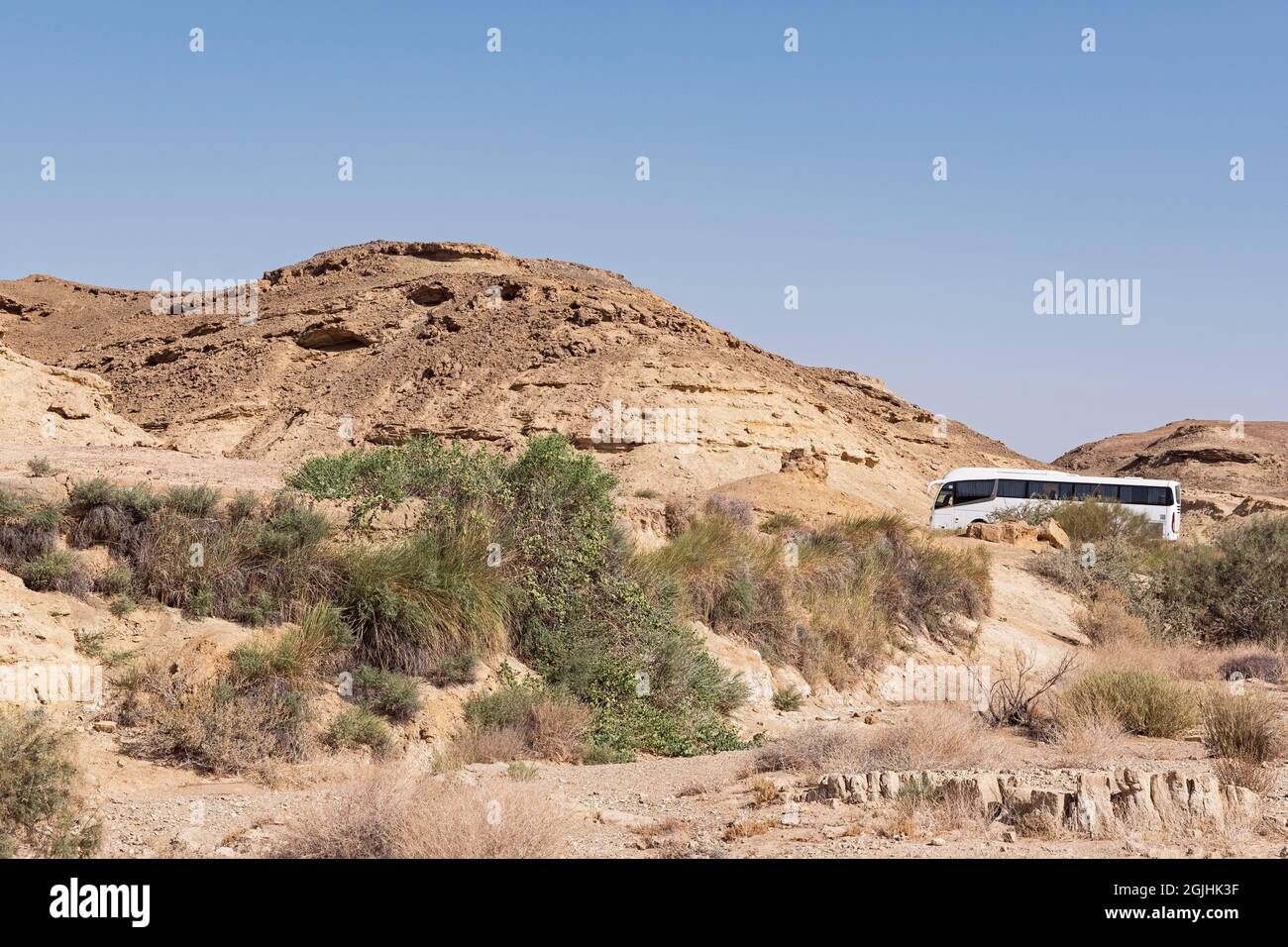 single white tour bus parked in the wilderness at the Ein Saharonim ...