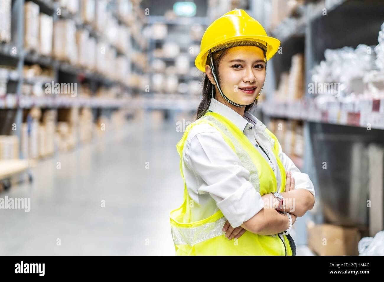 Asian woman warehouse worker are posing and smiling to the camera in a ...