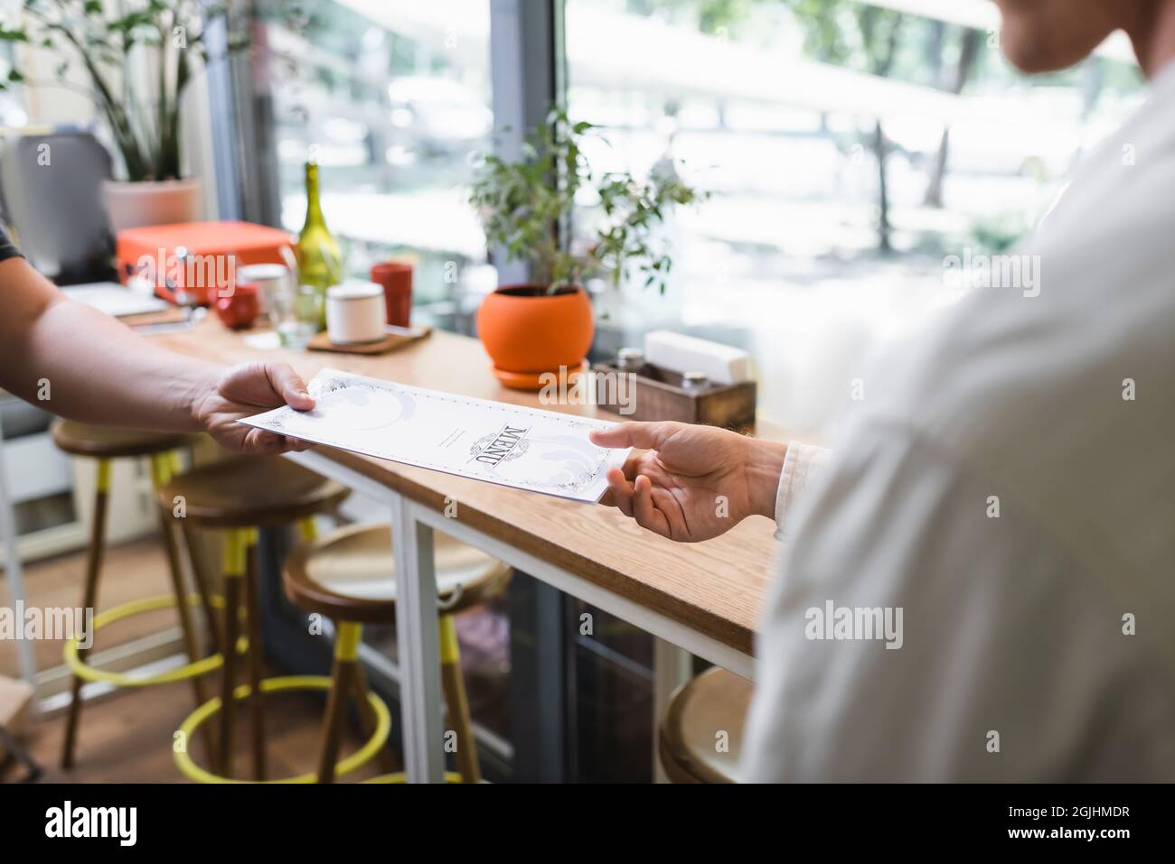 cropped view of waiter giving menu to client in cafe Stock Photo - Alamy