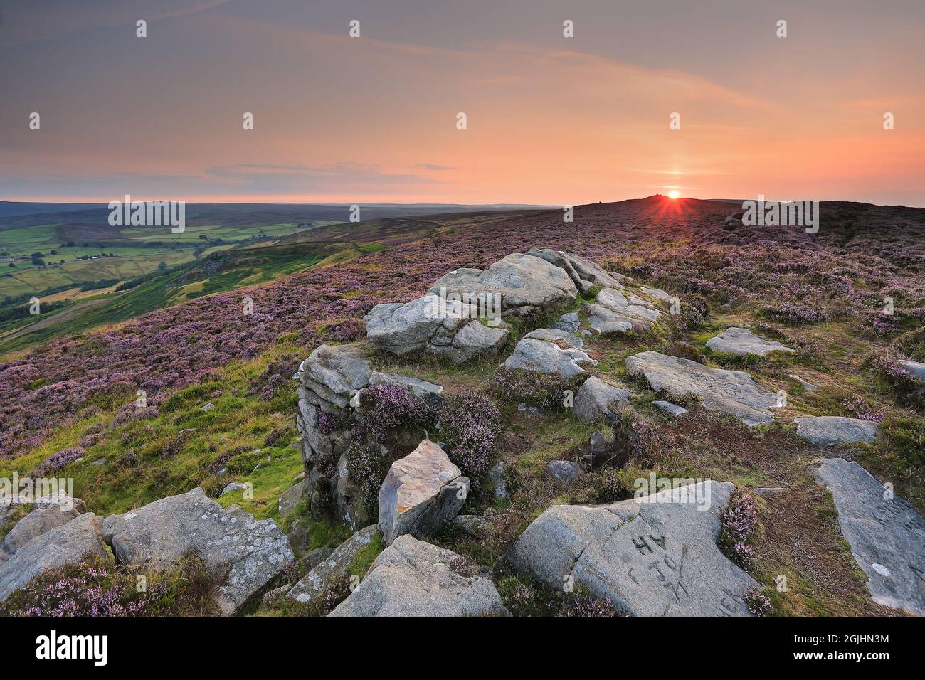 The sun rises over an outcrop of gritstone on the summit of Beamsley ...