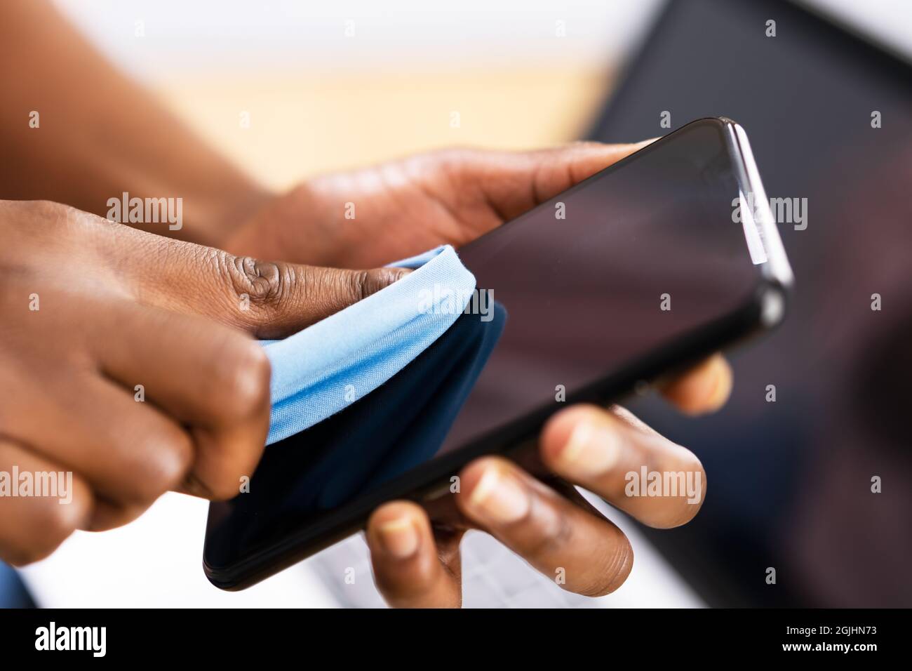 African Hand Cleaning Mobile Phone Or Smartphone Stock Photo - Alamy