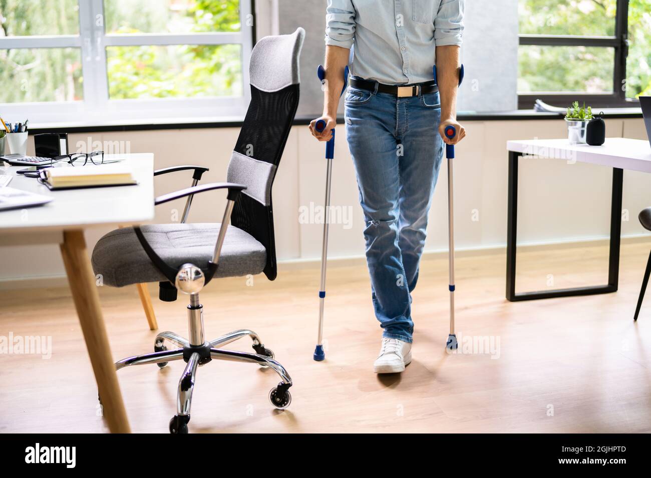 Worker With Crutches At Workplace Or Office. Handicap Rehabilitation ...