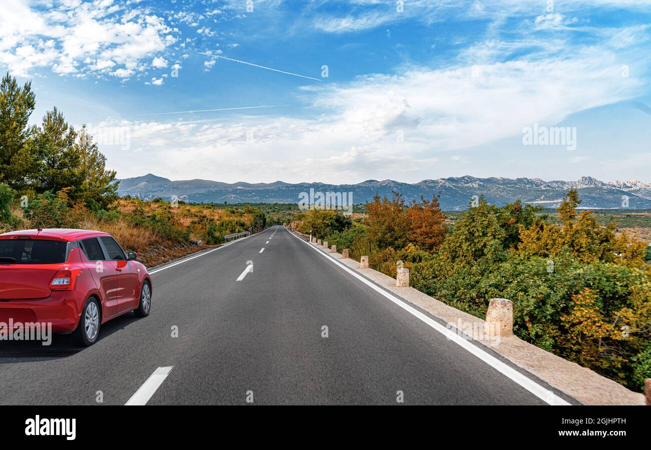 Red car on a scenic road Stock Photo - Alamy