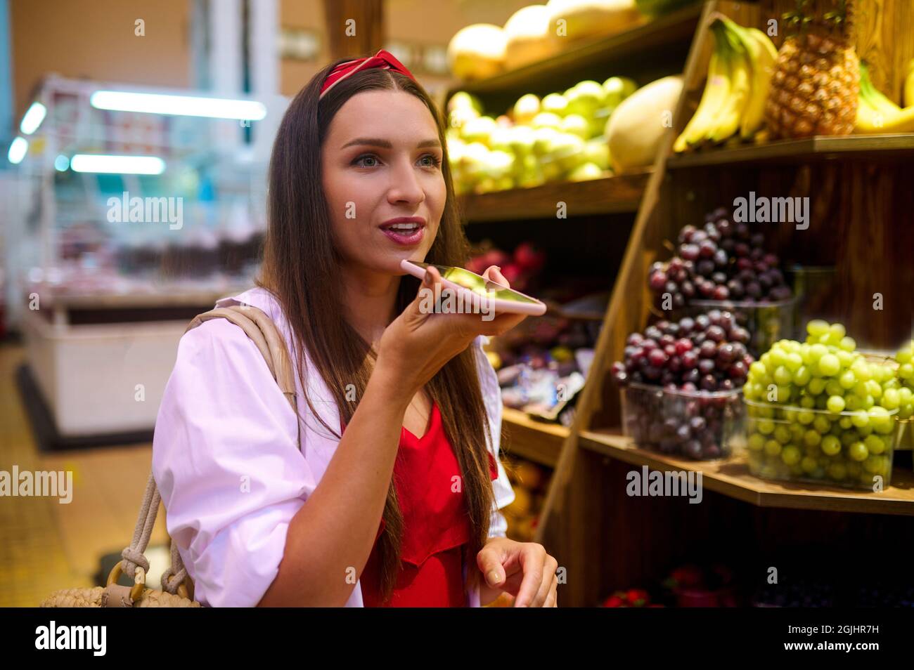 A young woman choosing fruits in a store Stock Photo - Alamy