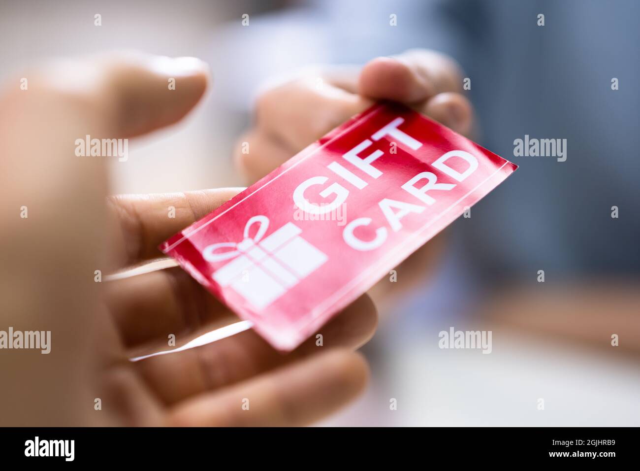 Hand Giving Gift Voucher Card. Holding Prepaid Coupon Stock Photo - Alamy