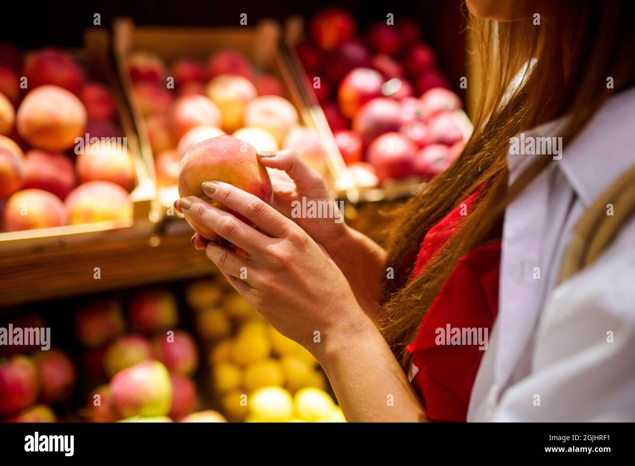 A woman choosing fruits in a store and looking involved Stock Photo - Alamy