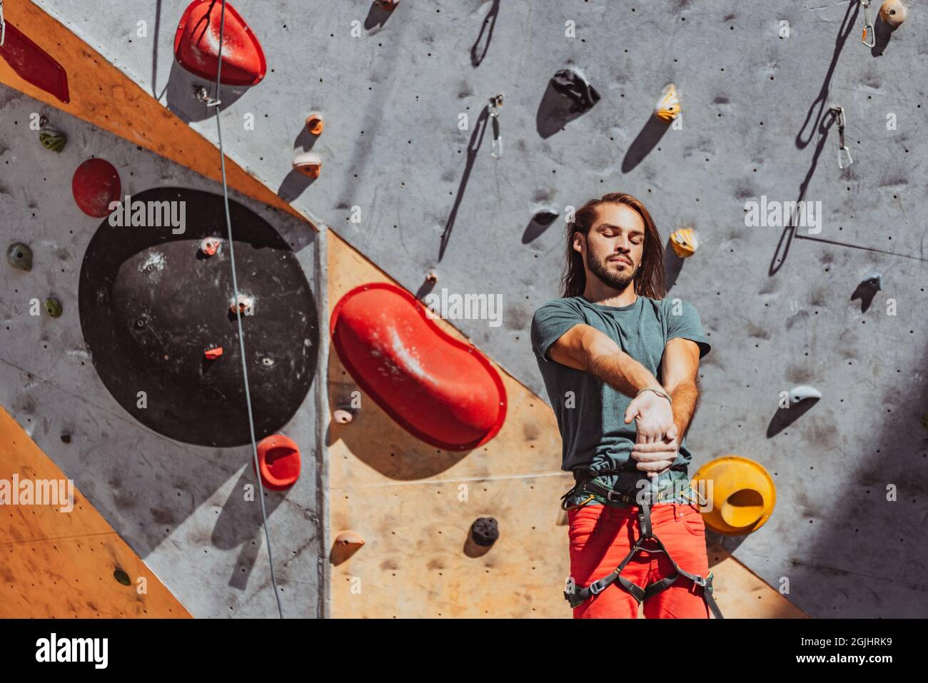 Portrait of Caucasian man professional rock climber warms-up at front ...