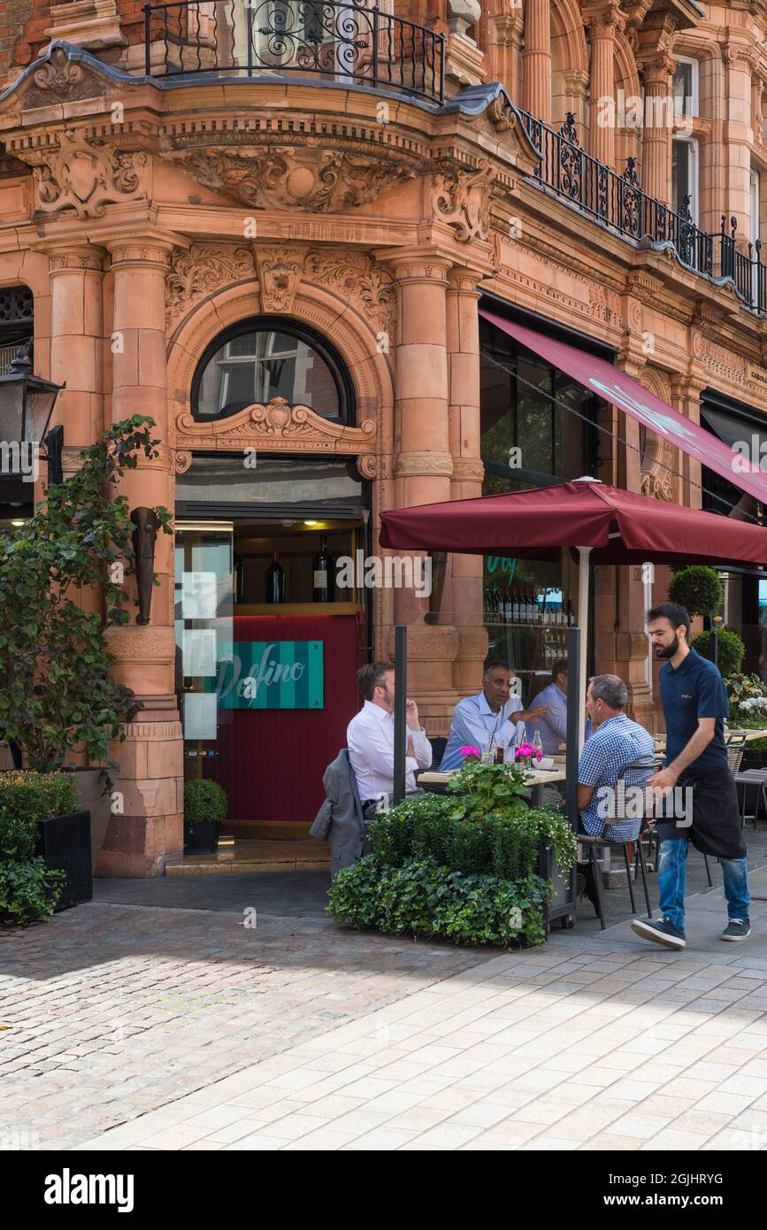 People seated at pavement tables dining al fresco outside Delfino ...