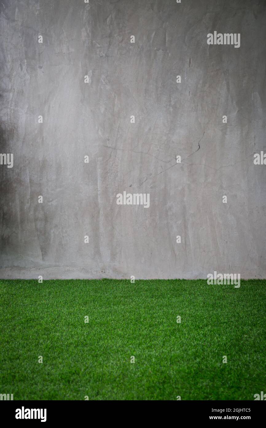 Green grass artificial turf pattern with gray cement wall background ...