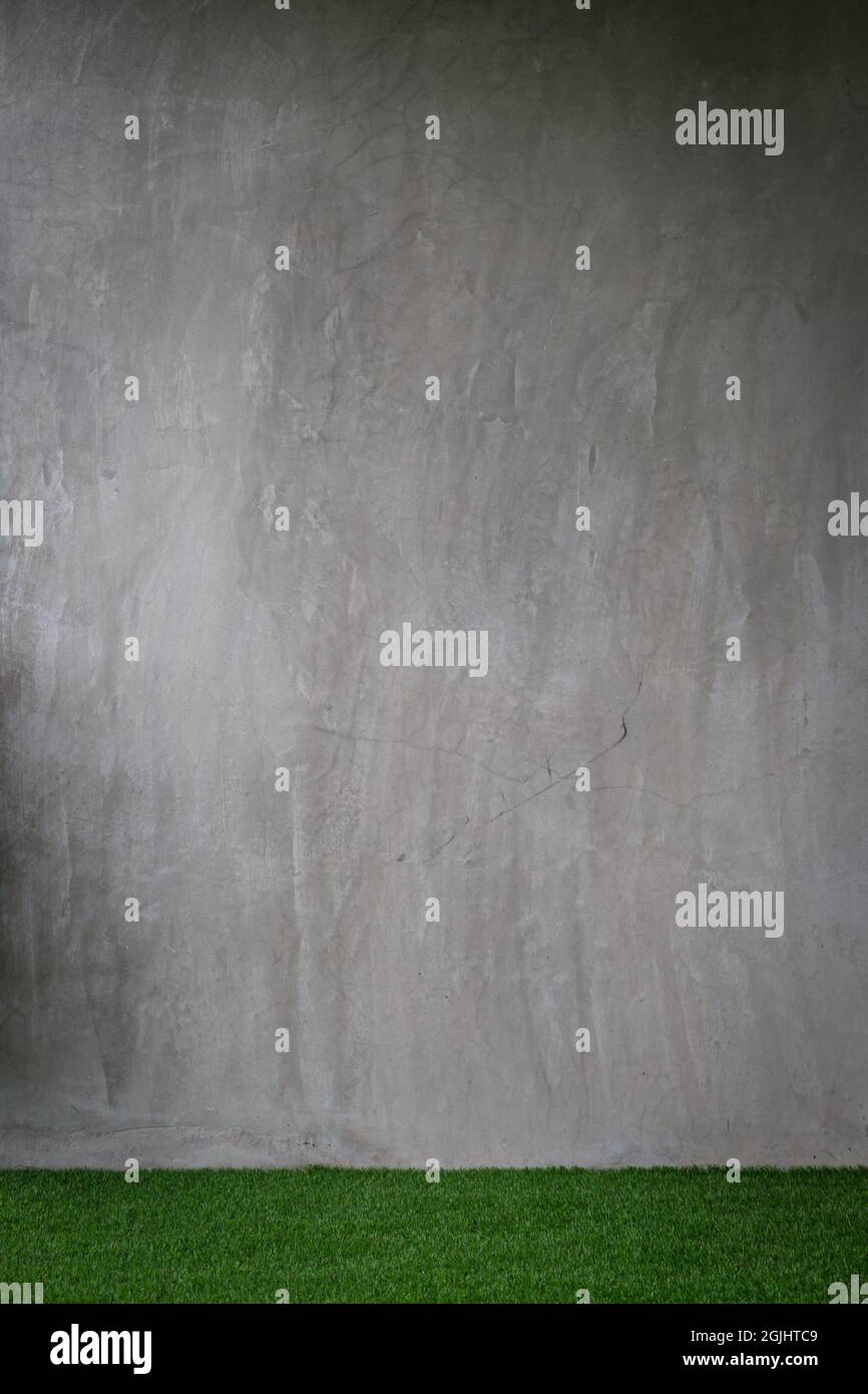 Green grass artificial turf pattern with gray cement wall background ...