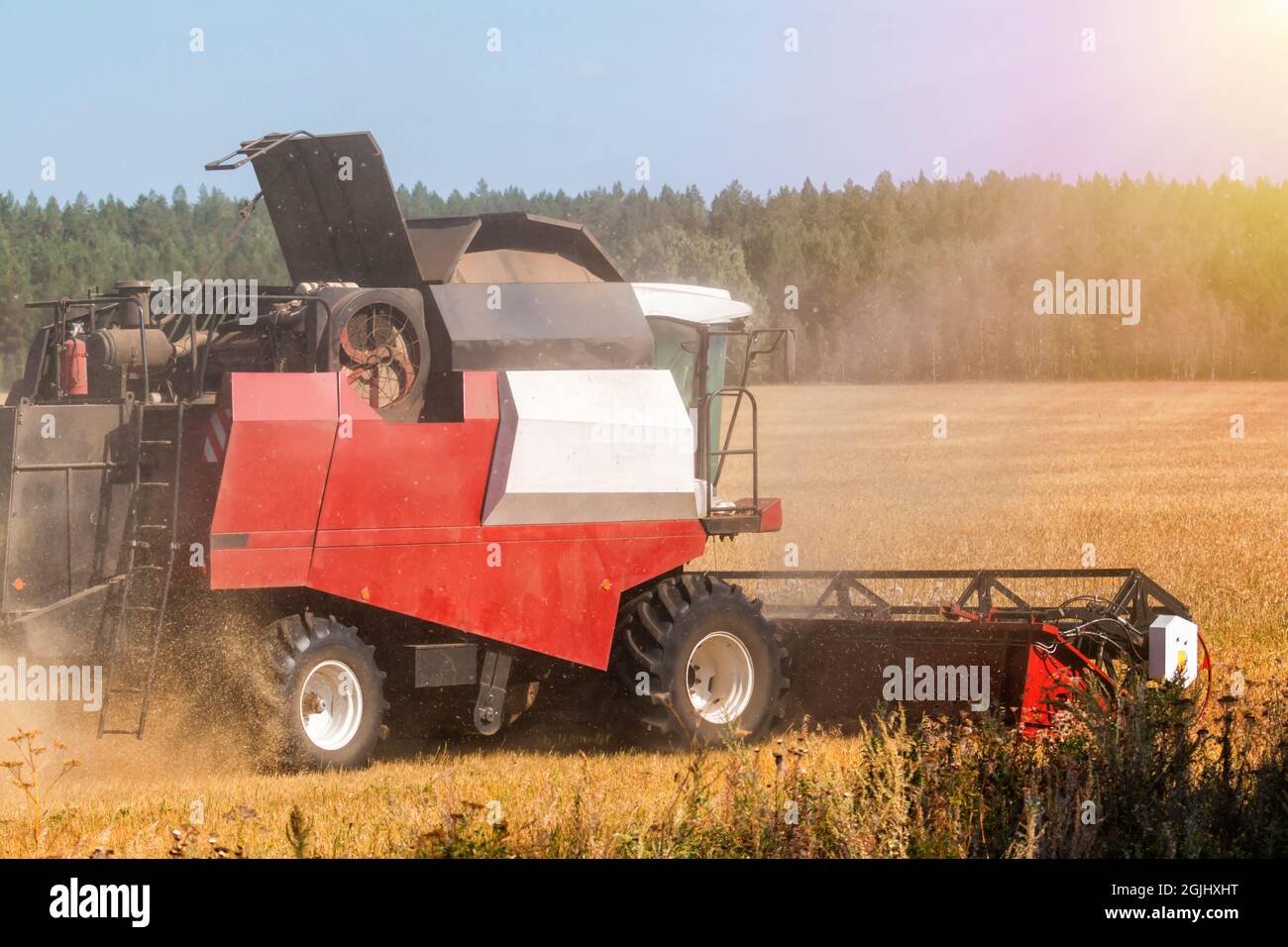 Modern combine harvester working in the field on a clear sunny day ...