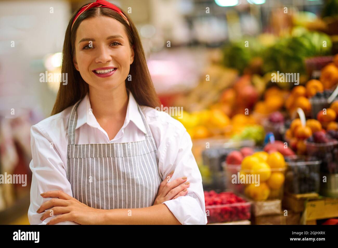A picture of a young woman in an apron in a fruits store Stock Photo ...