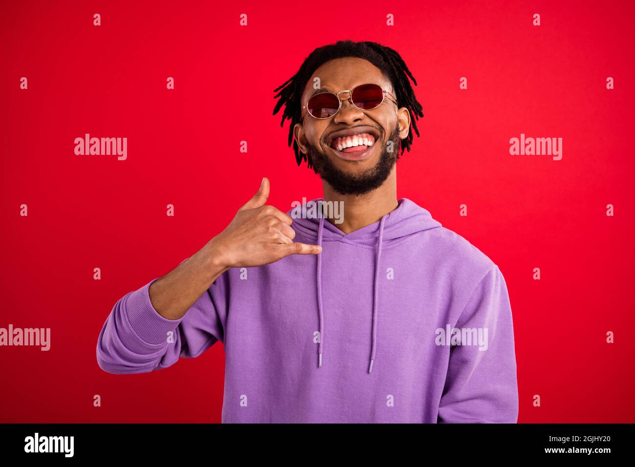 Portrait of attractive funky cheerful guy showing call me sign having ...