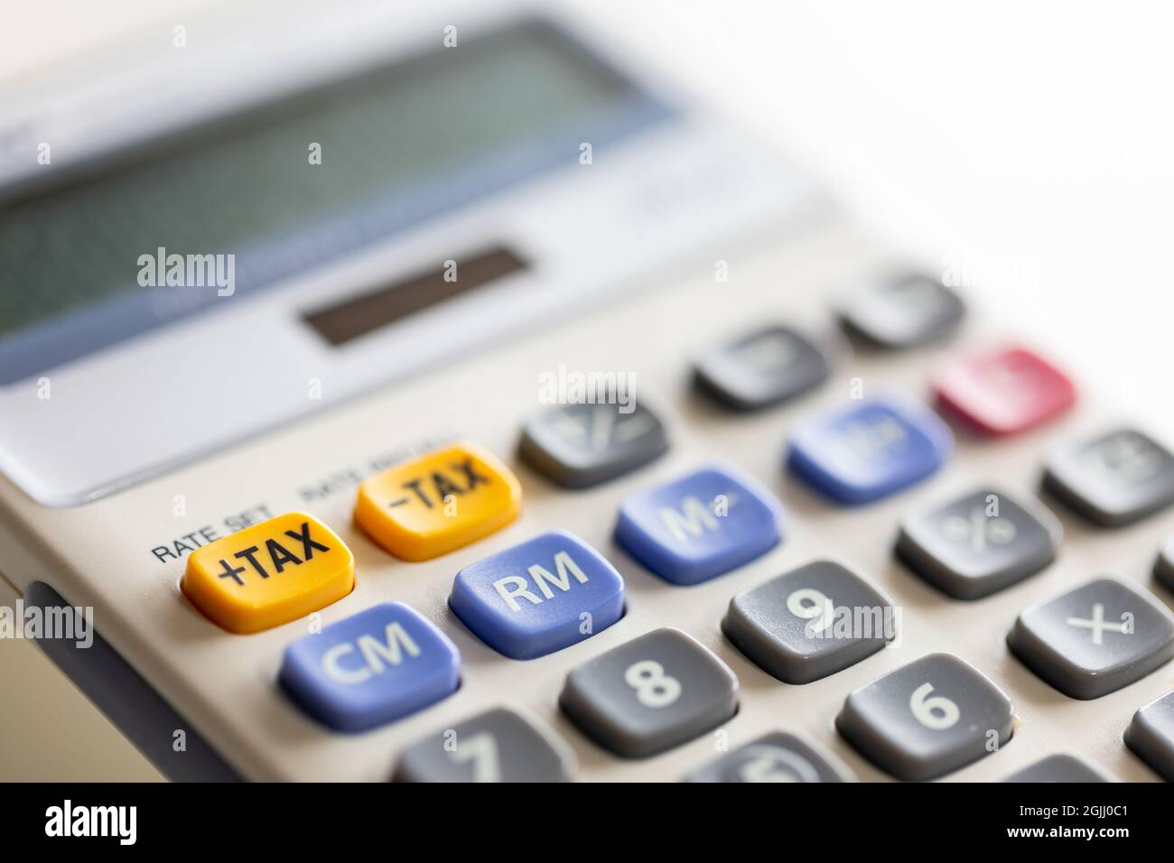 Selective focus on plus tax yellow button of calculator with blurry ...
