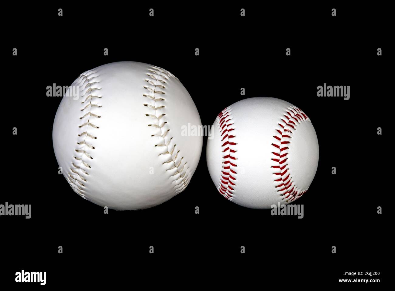 Large and small softballs isolated against a black background Stock ...