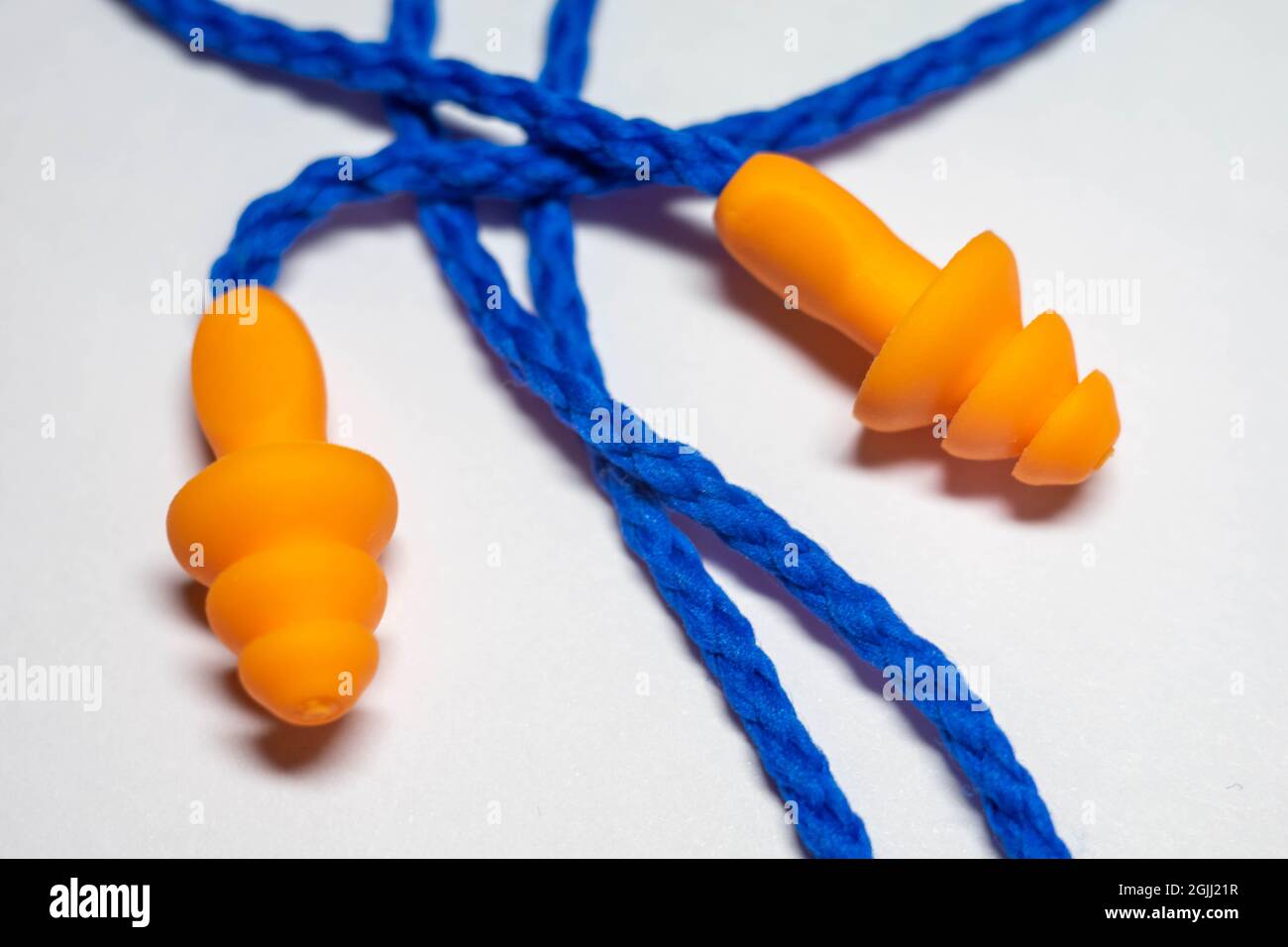 New orange earplugs with blue rope on a white table Stock Photo - Alamy