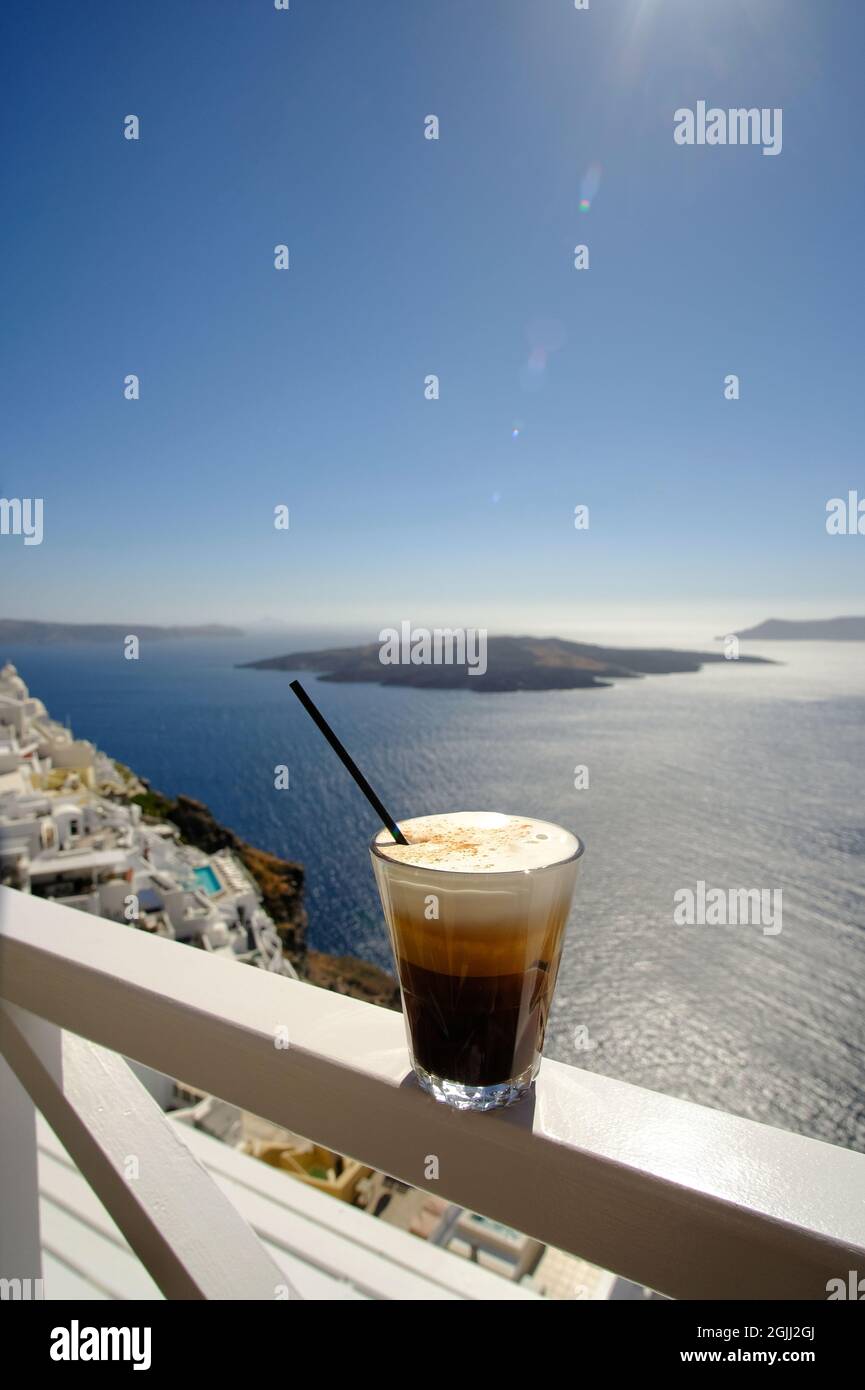 Panoramic view of the famous caldera and an iced greek coffee, also ...