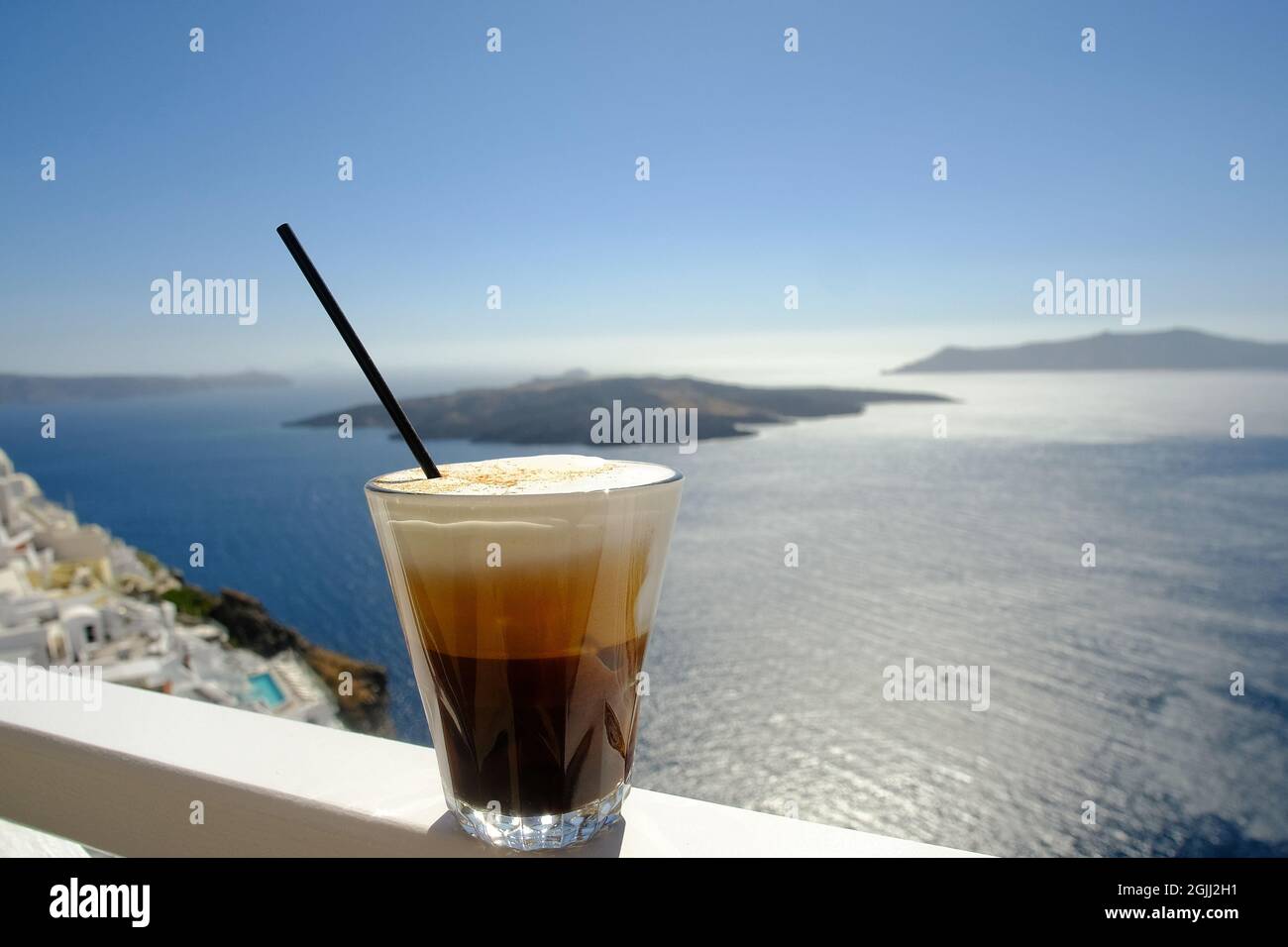 Panoramic view of the famous caldera and an iced greek coffee, also known as freddo cappuccino ...