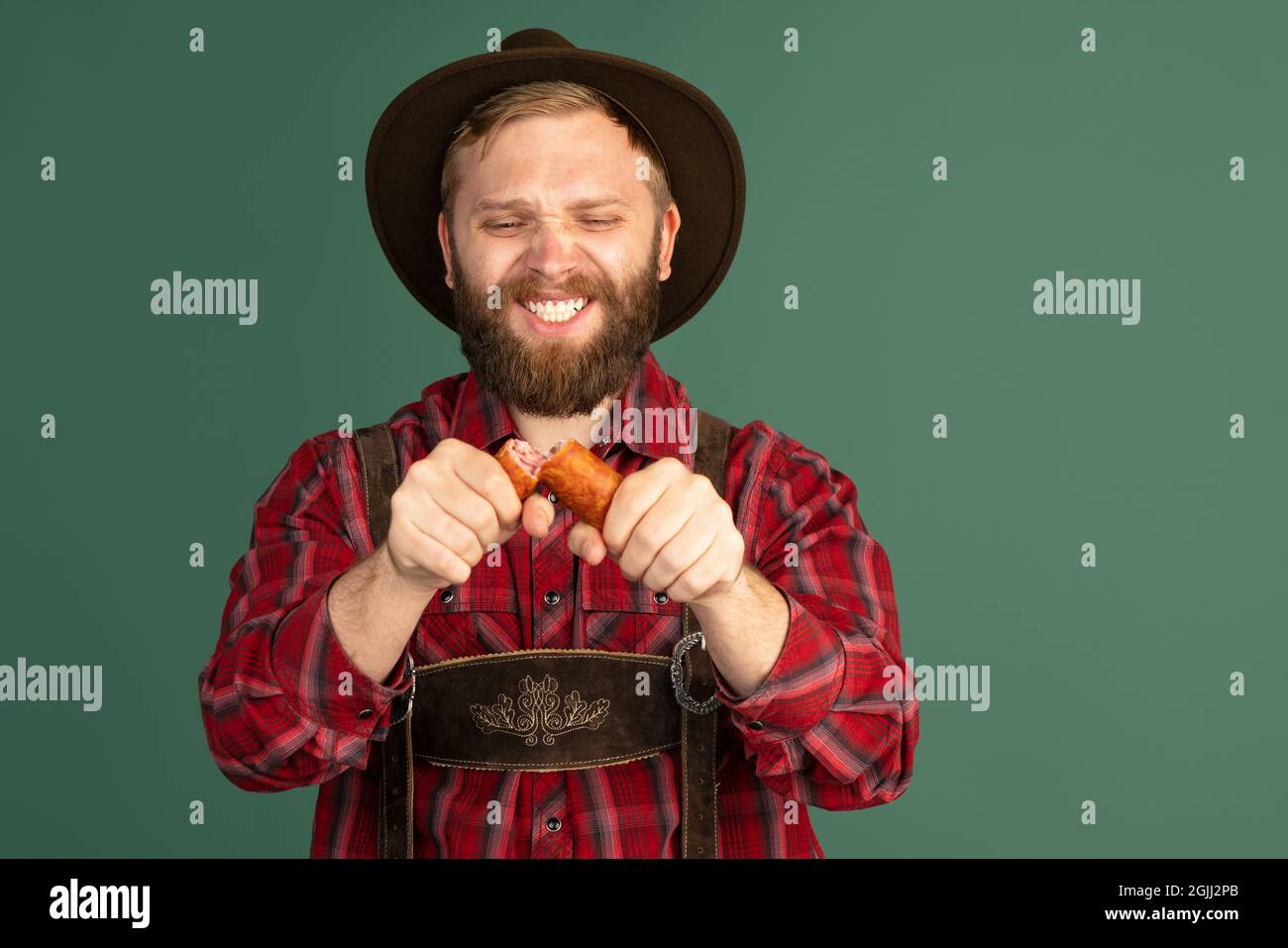 Portrait of bearded man in traditional Bavarian costume with sausages ...