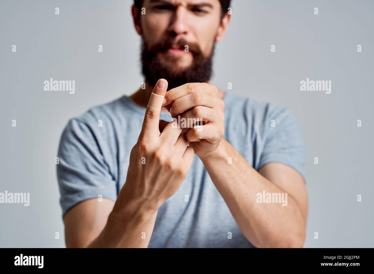bearded man sticks his finger with a plaster treating health problems ...