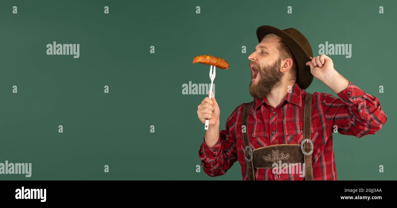 Portrait of bearded man in traditional Bavarian costume with sausages ...