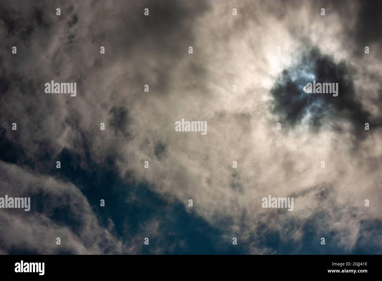 Sun obscured by clouds on the blue sky | Dramatic sky with sun shining ...