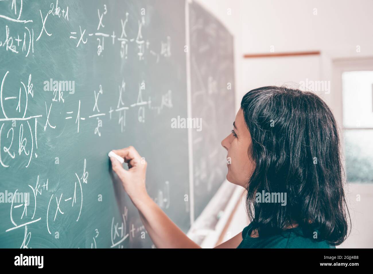 Teacher or student writing on blackboard during math lesson in school ...